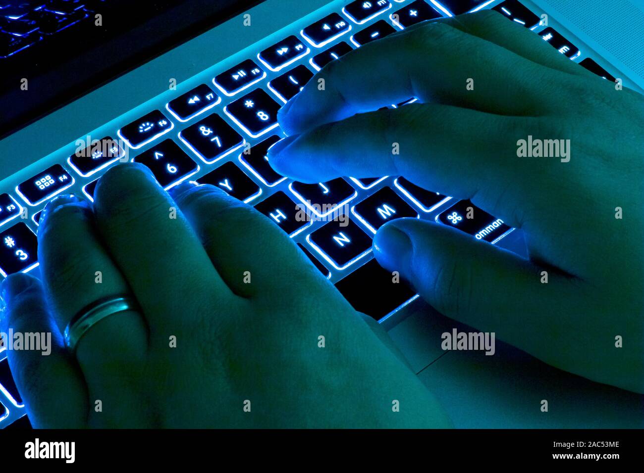 A Person typing at night on a laptop Stock Photo - Alamy