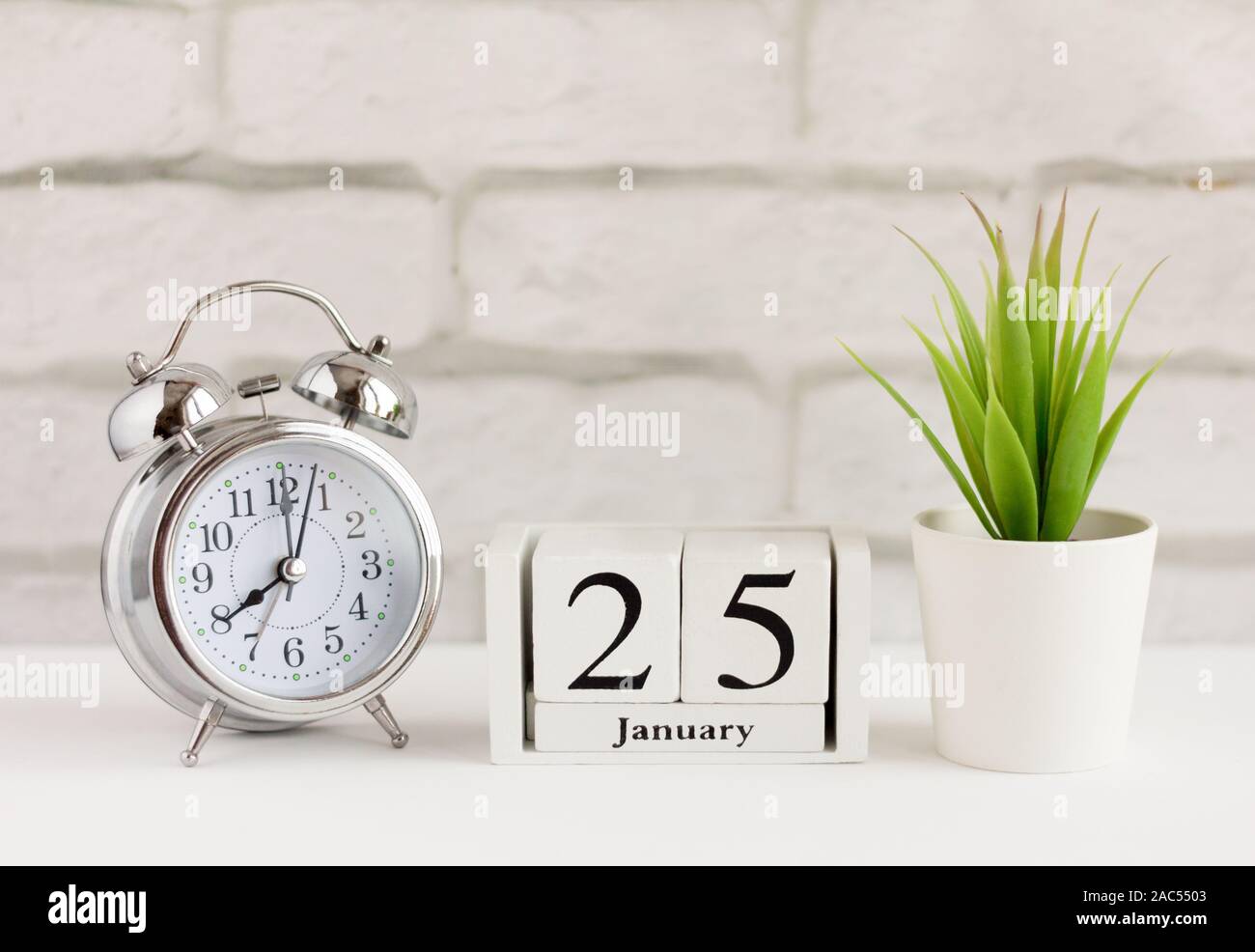Wooden calendar next to the alarm clock, January 25 in the yard Stock ...