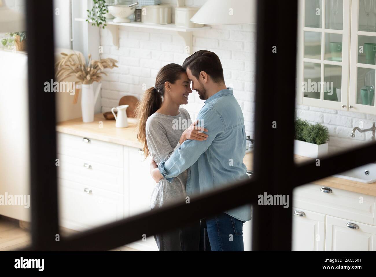Affectionate romantic couple embracing in modern kitchen at home Stock ...