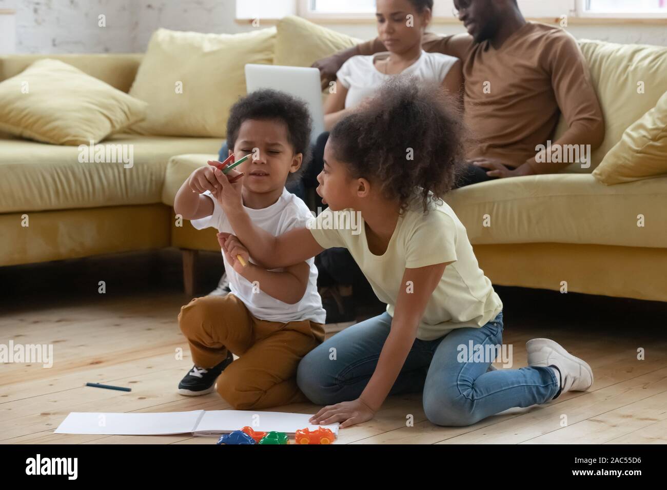 Small biracial kids sit on floor drawing together Stock Photo - Alamy