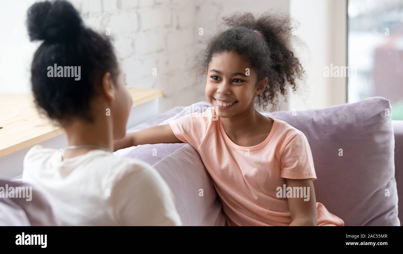 Smiling little girl talk sharing secret with mum Stock Photo - Alamy