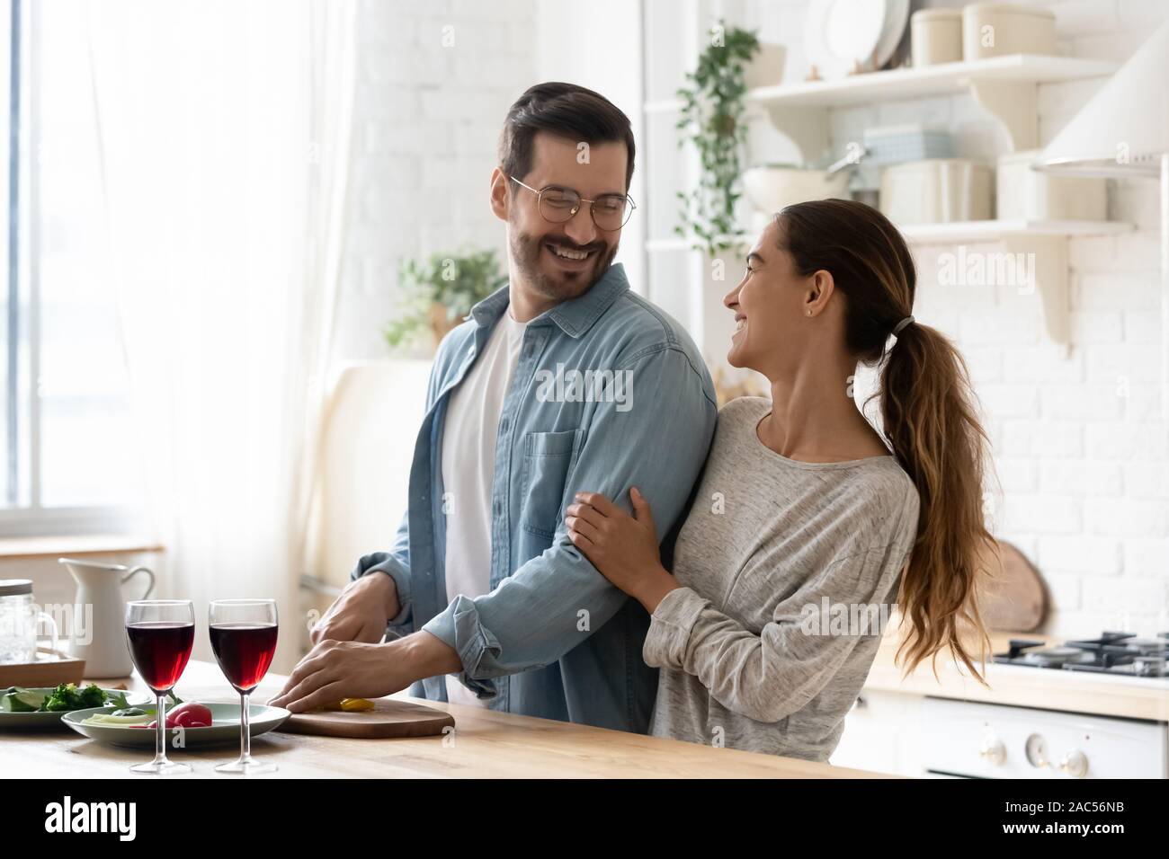 Happy married couple cooking together preparing healthy meal in kitchen ...