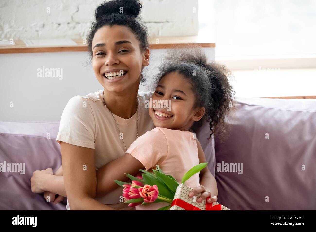 Happy african American mom and daughter hug celebrating birthday Stock Photo - Alamy