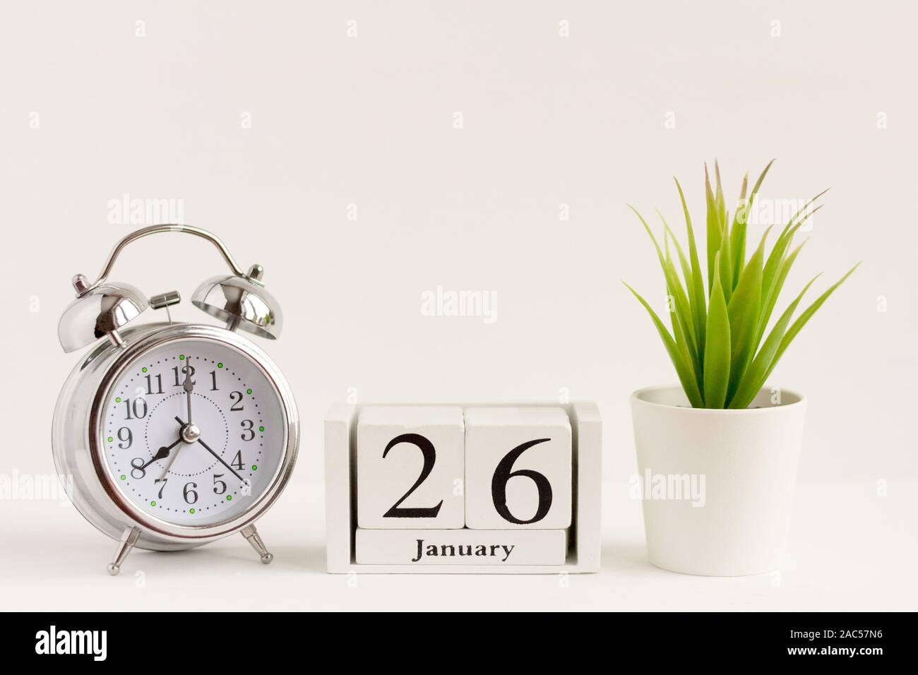 January 26 on a wooden calendar next to the alarm clock.Calendar date ...