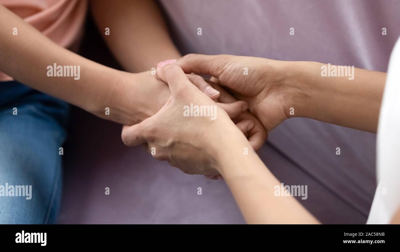 African American mom and daughter hold hands talking Stock Photo - Alamy