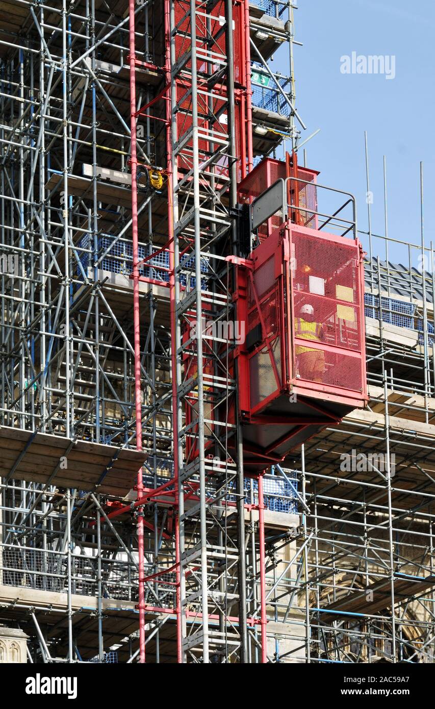 metal elevator leading high up alongside scaffolding at facade of a ...