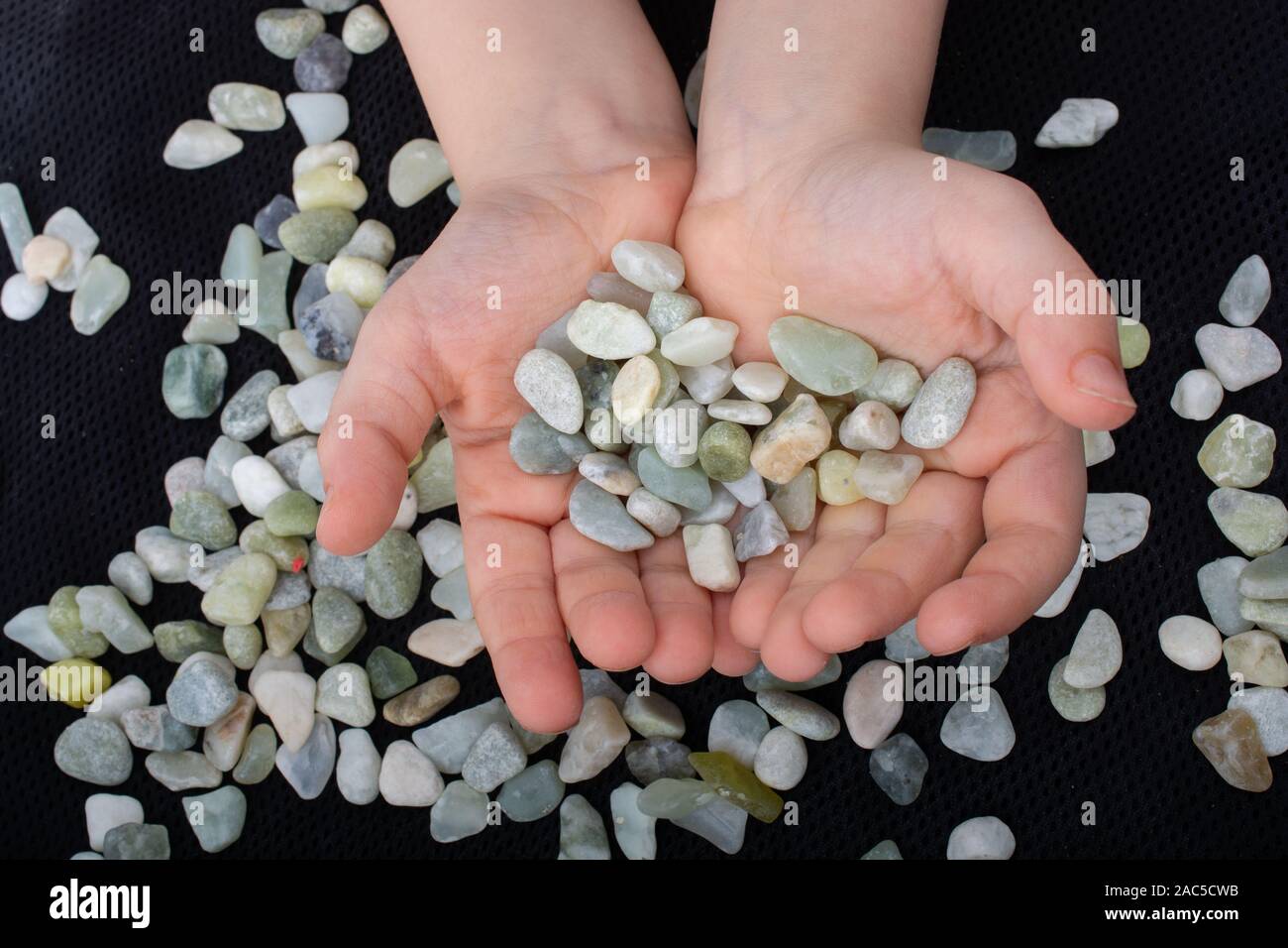 Handful of clean pebbles, gravels in hands Stock Photo - Alamy