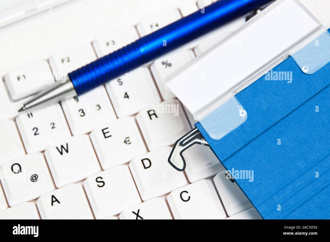 File folder with pen on keyboard Stock Photo - Alamy