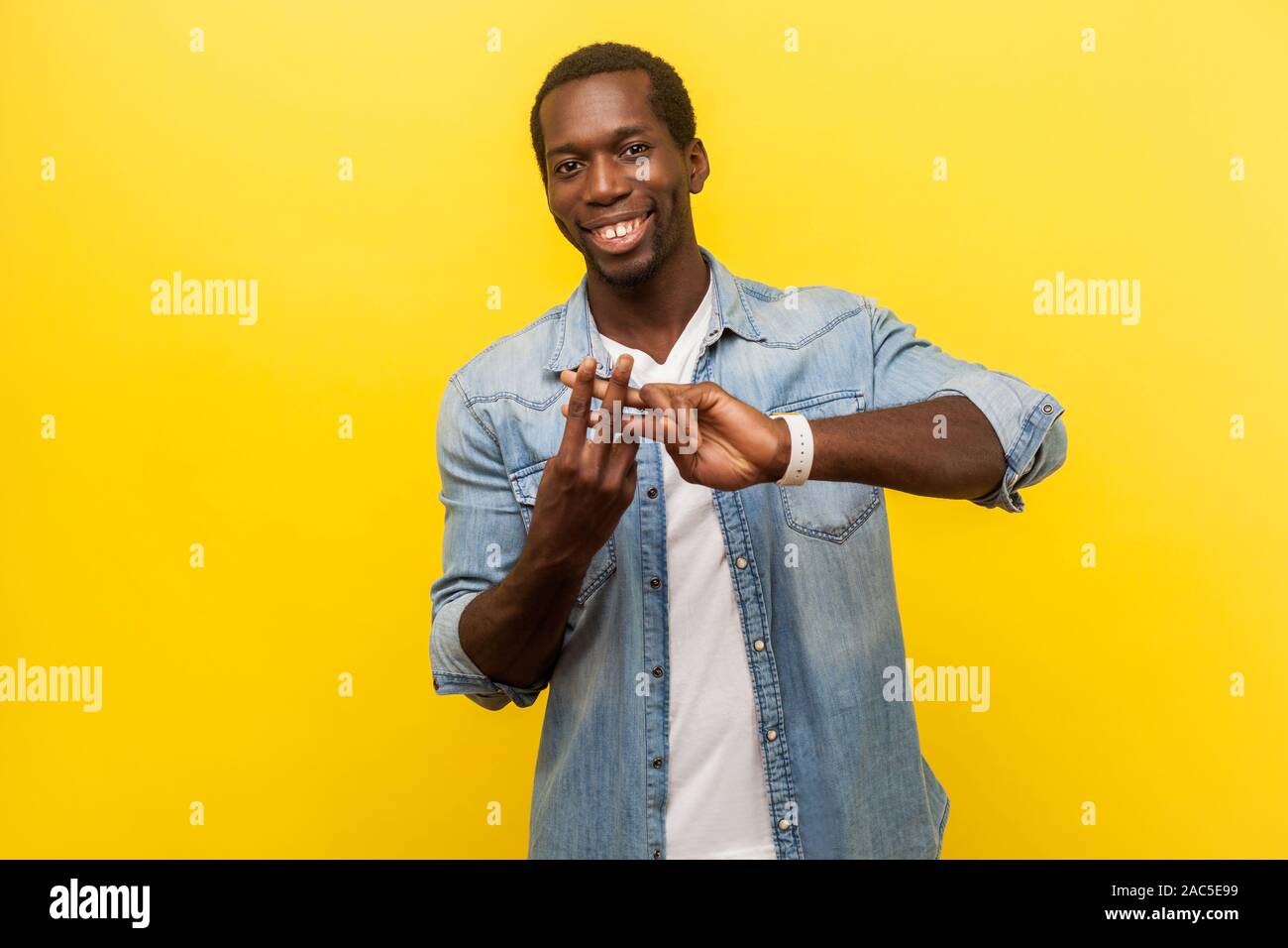 Hashtag symbol. Portrait of friendly joyful man in denim shirt making ...