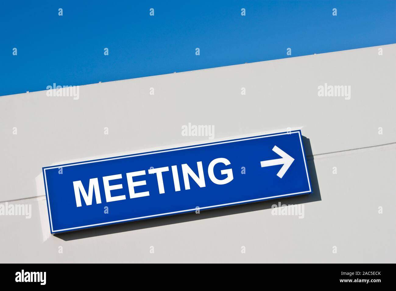 Meeting sign and blue background Stock Photo - Alamy