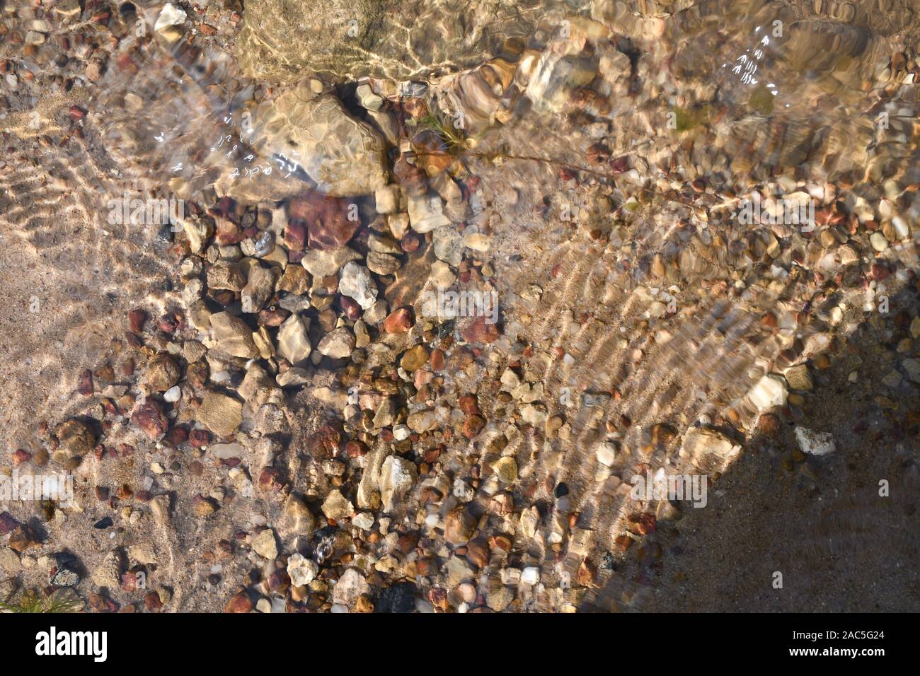 Stone in the water and water will sine of sunlight Stock Photo - Alamy