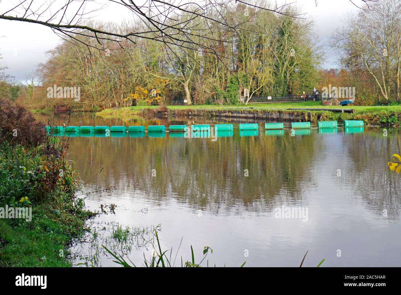 A boom on the River Bure upstream of the weir and remains of the old ...