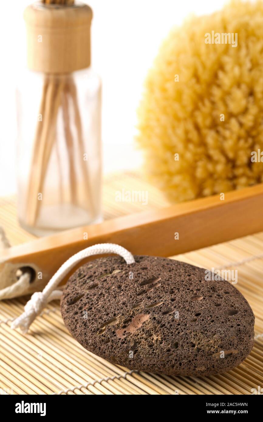 Black lava pumice stone with natural spa or bath utensils used for ...