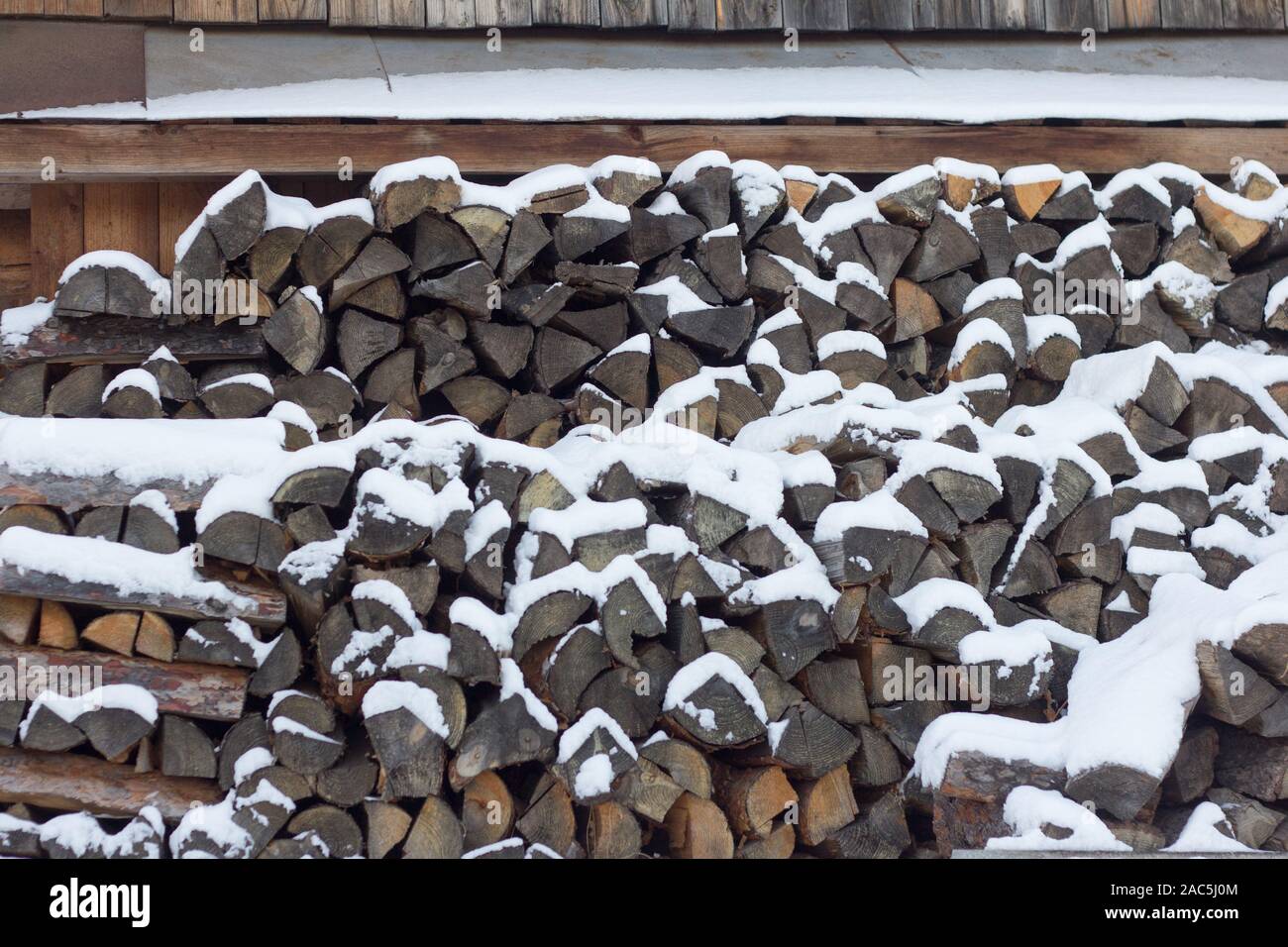 The pile of firewood in the yard.Wood for the stove under the snow ...