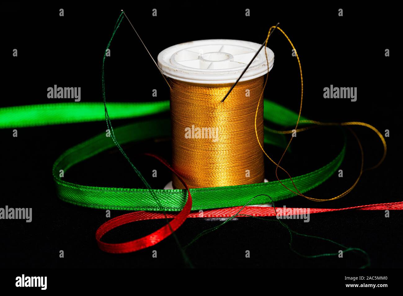 A spool of Gold Thread surrounded by needles and ribbon ready to use in ...