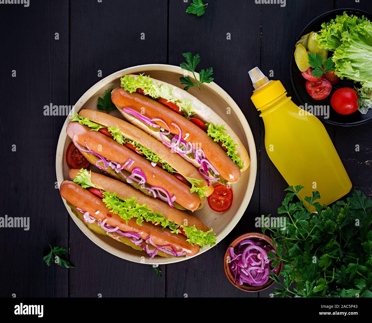 Hot dog with sausage, pickled cucumber, tomatoes, red onions and ...