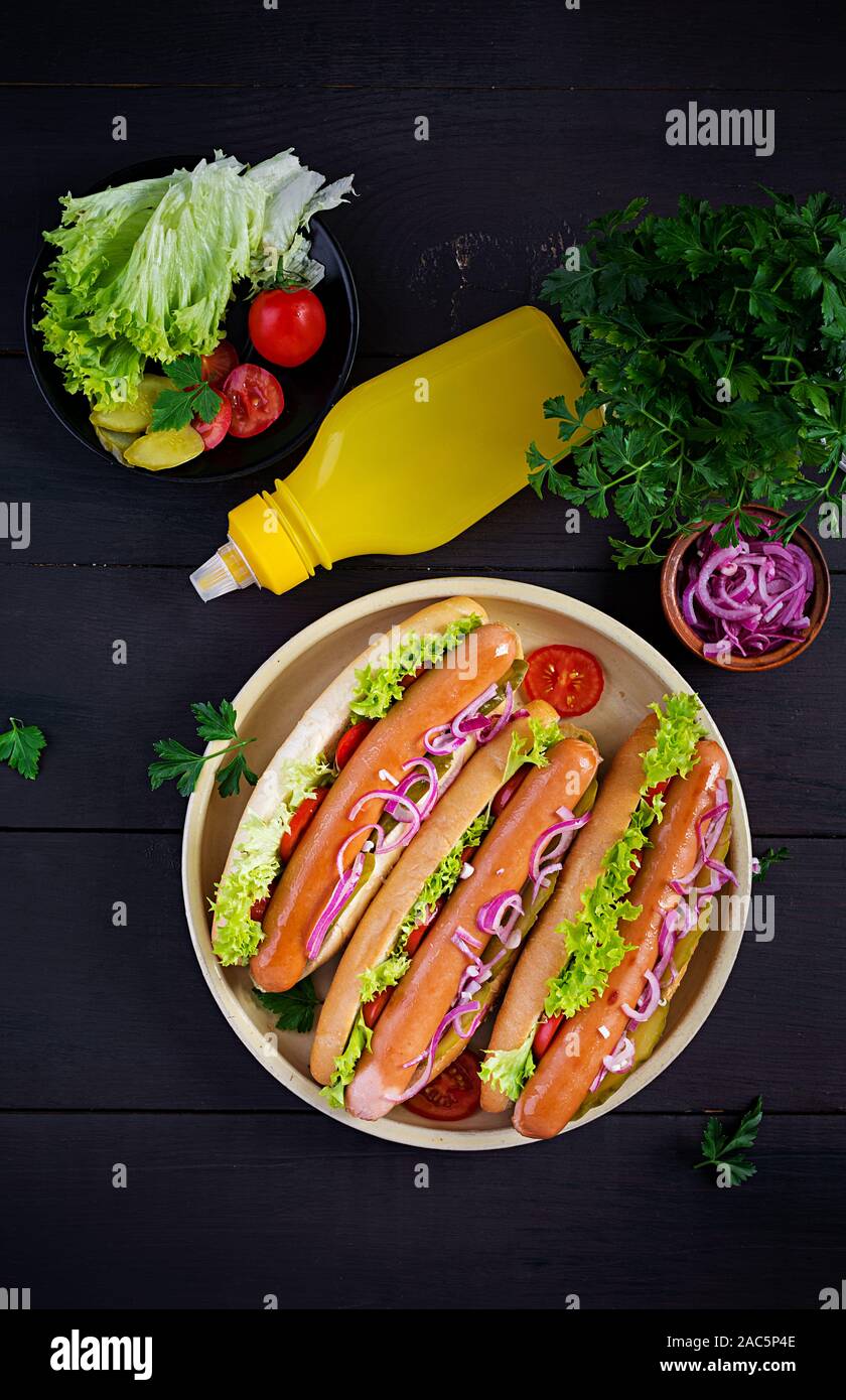 Hot dog with sausage, pickled cucumber, tomatoes, red onions and ...
