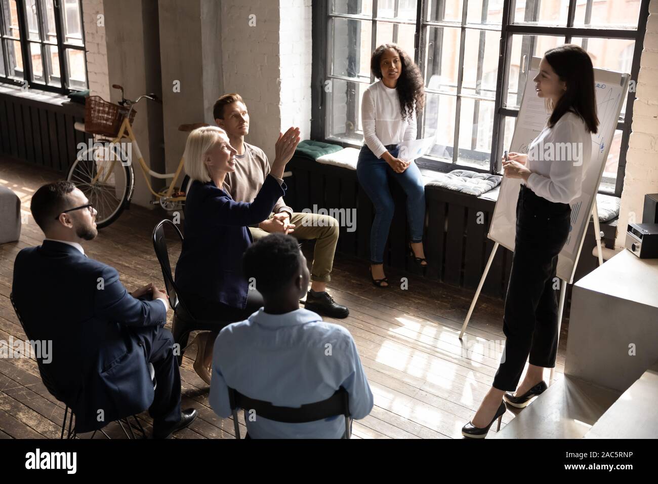 Middle aged pleasant business woman raising hand, asking questions ...
