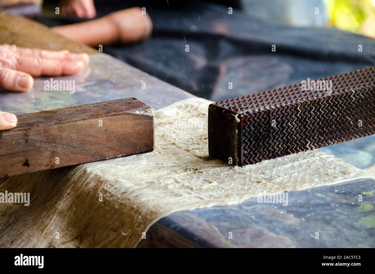 A close-up of Roen Hufford using wooden tools to make kapa (or tapa ...