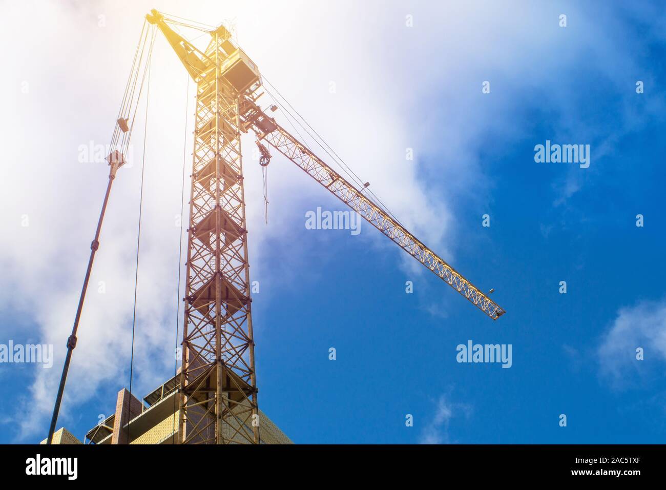 Buildings under construction and cranes under a blue sky. Bright Sunny ...