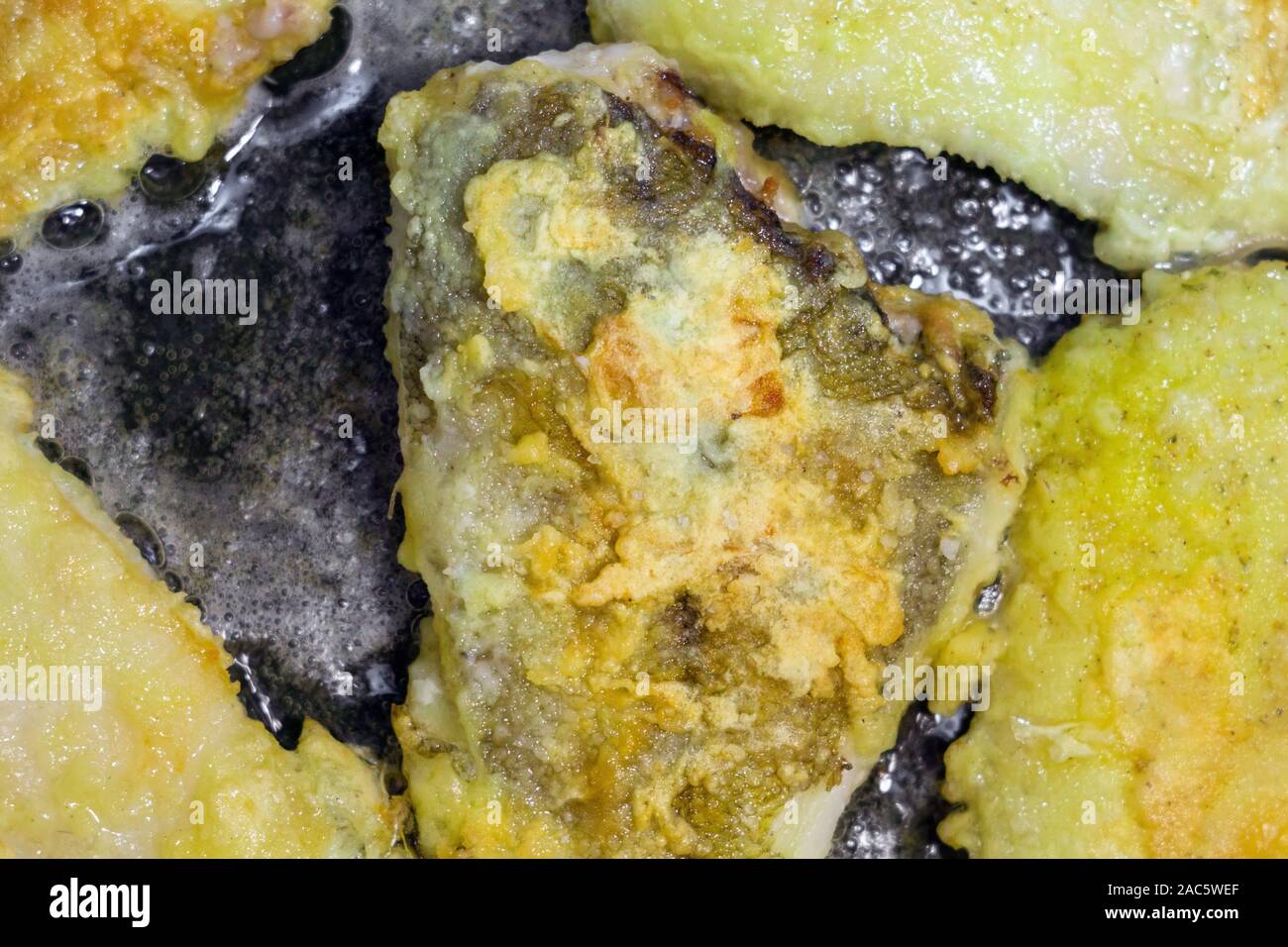pieces of fried yellow fish flounder, fried in a frying pan. Cooking ...