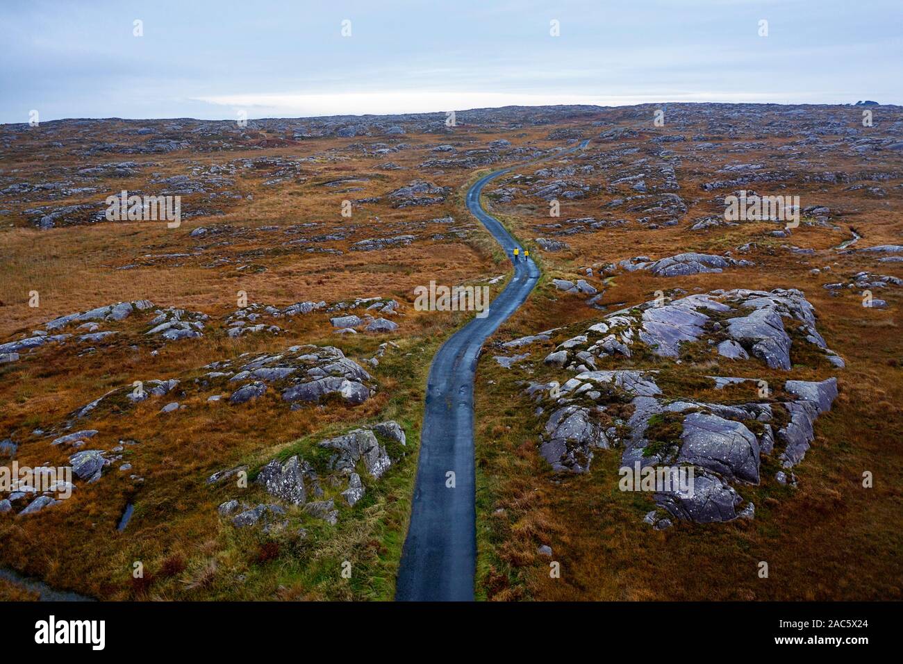 Aerial view of mother and son walking on the road in rough landscape on ...