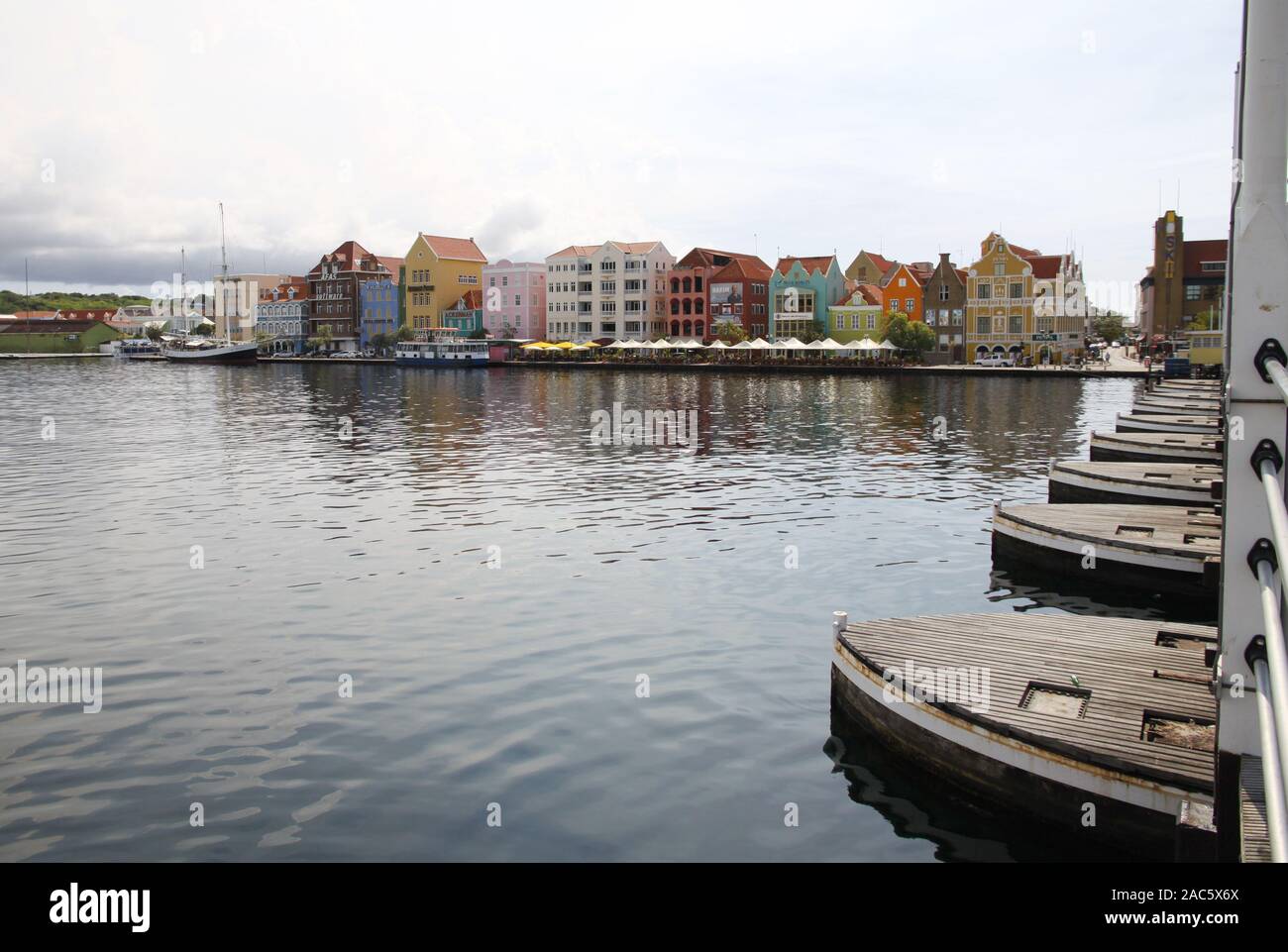the queen Emma bridge, a pontoon bridge. Colorful houses of Otro Banda ...