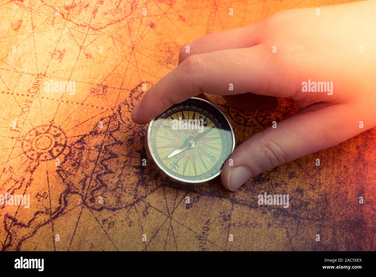 Hand is holding a magnetic compass on black background Stock Photo - Alamy