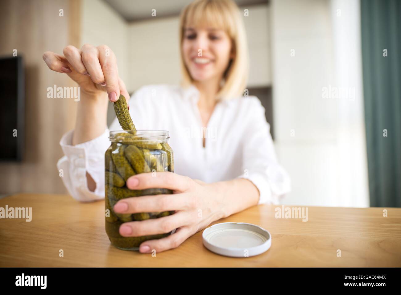 Pregnant woman eating pickles in kitchen Stock Photo - Alamy