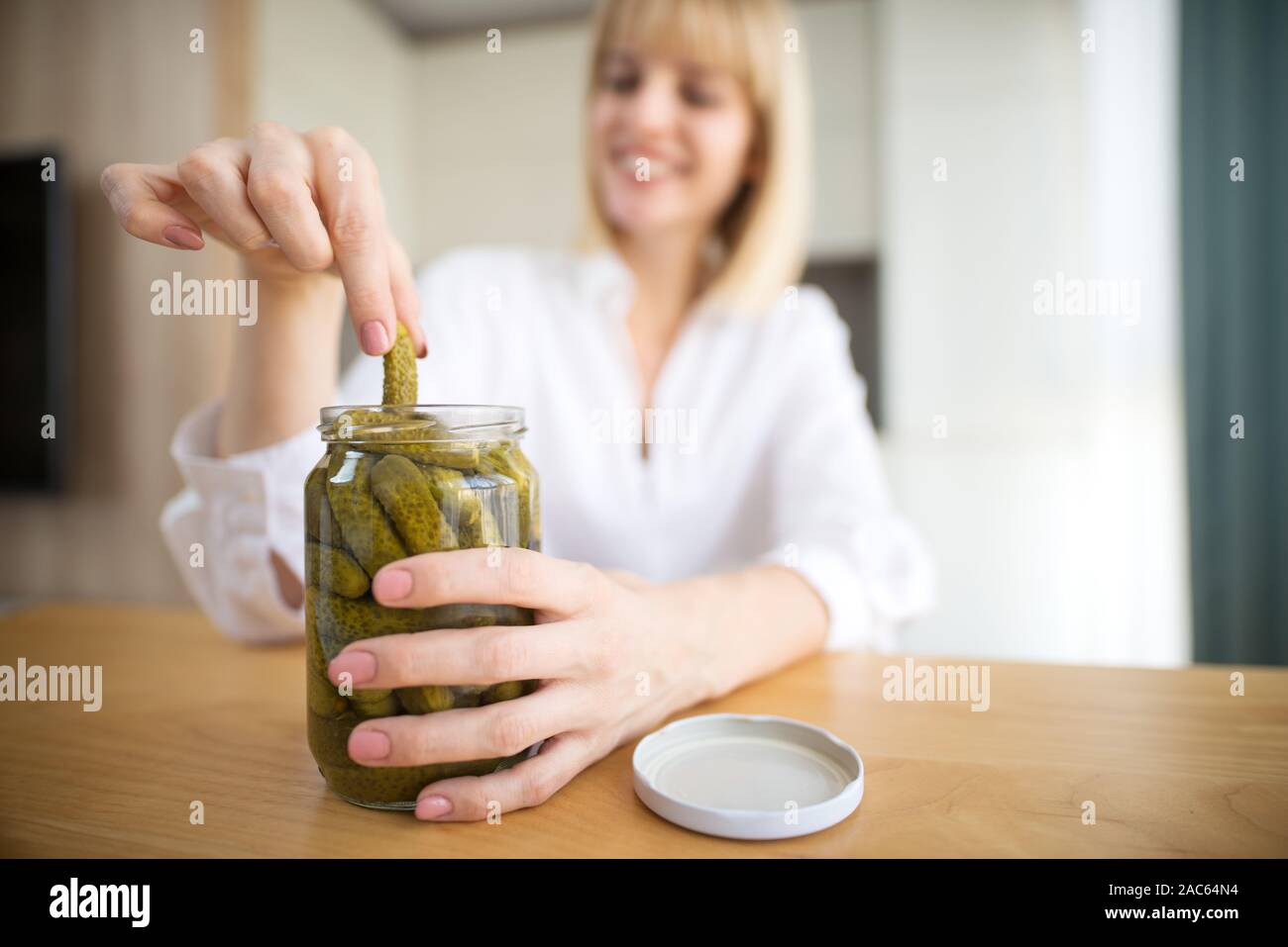 Pregnant woman eating pickles in kitchen Stock Photo - Alamy