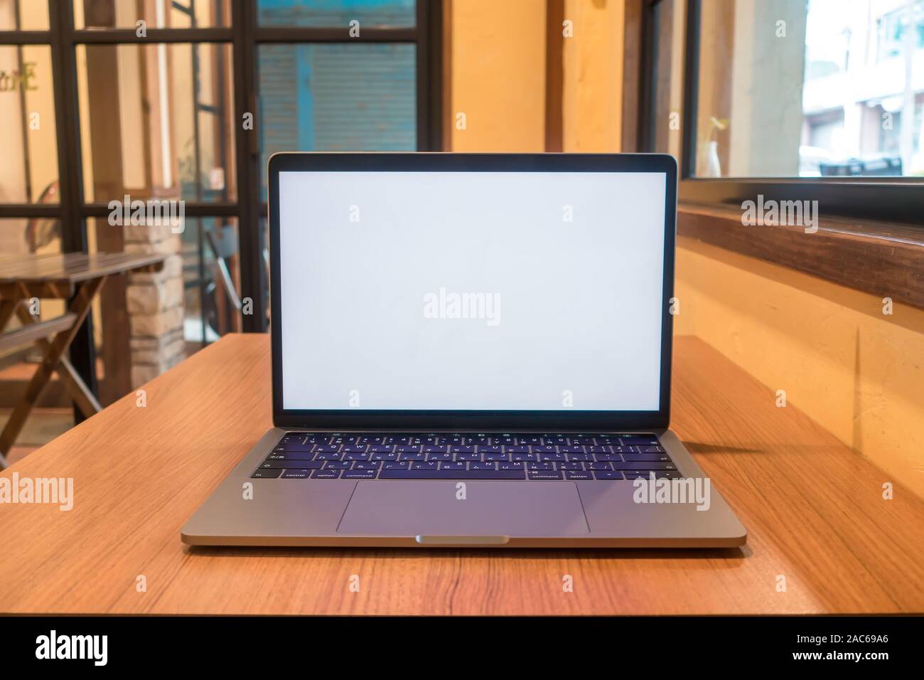 Conceptual workspace, Laptop computer with blank white screen on table ...