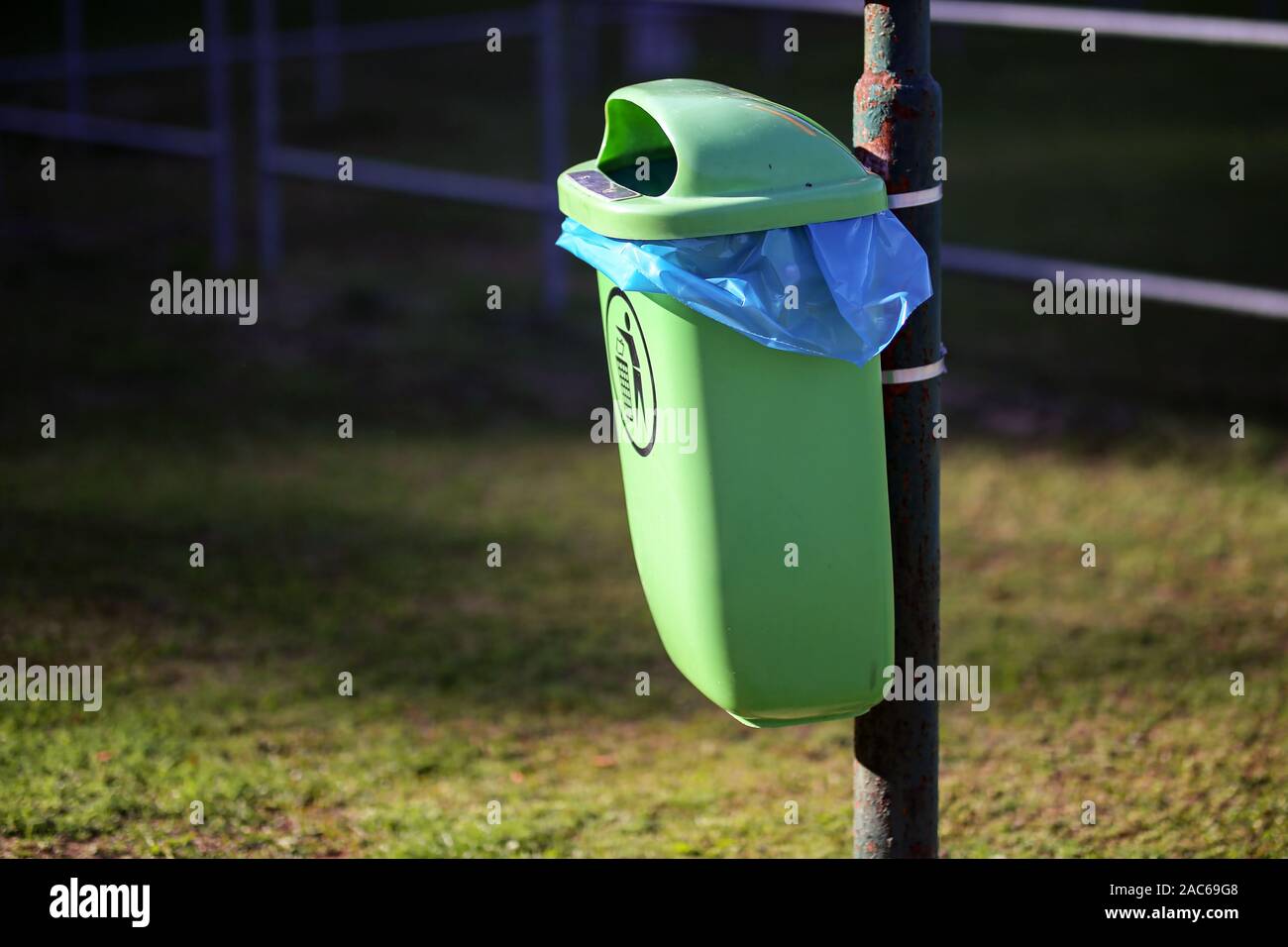 green trash can in a city park Stock Photo - Alamy
