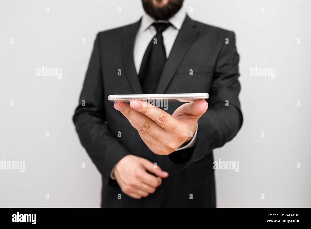 Male human wear formal work suit hold smart hi tech smartphone use one ...