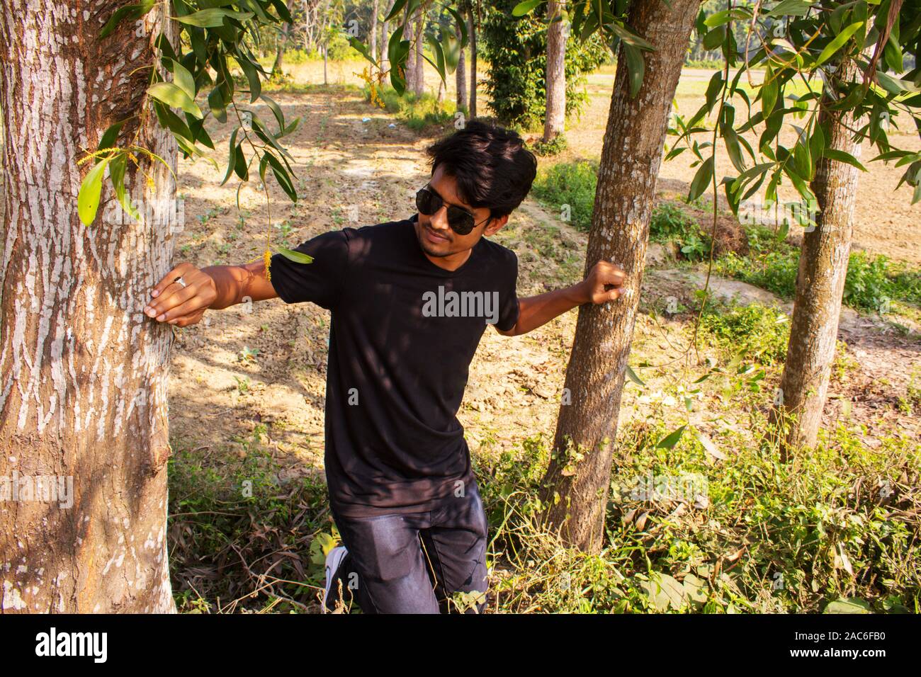 A Young boy wearing sun glass,posing with style, background is nature ...