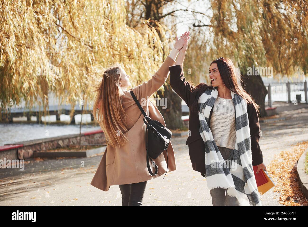 High five. Two young friends are glad to meet each other at park after ...