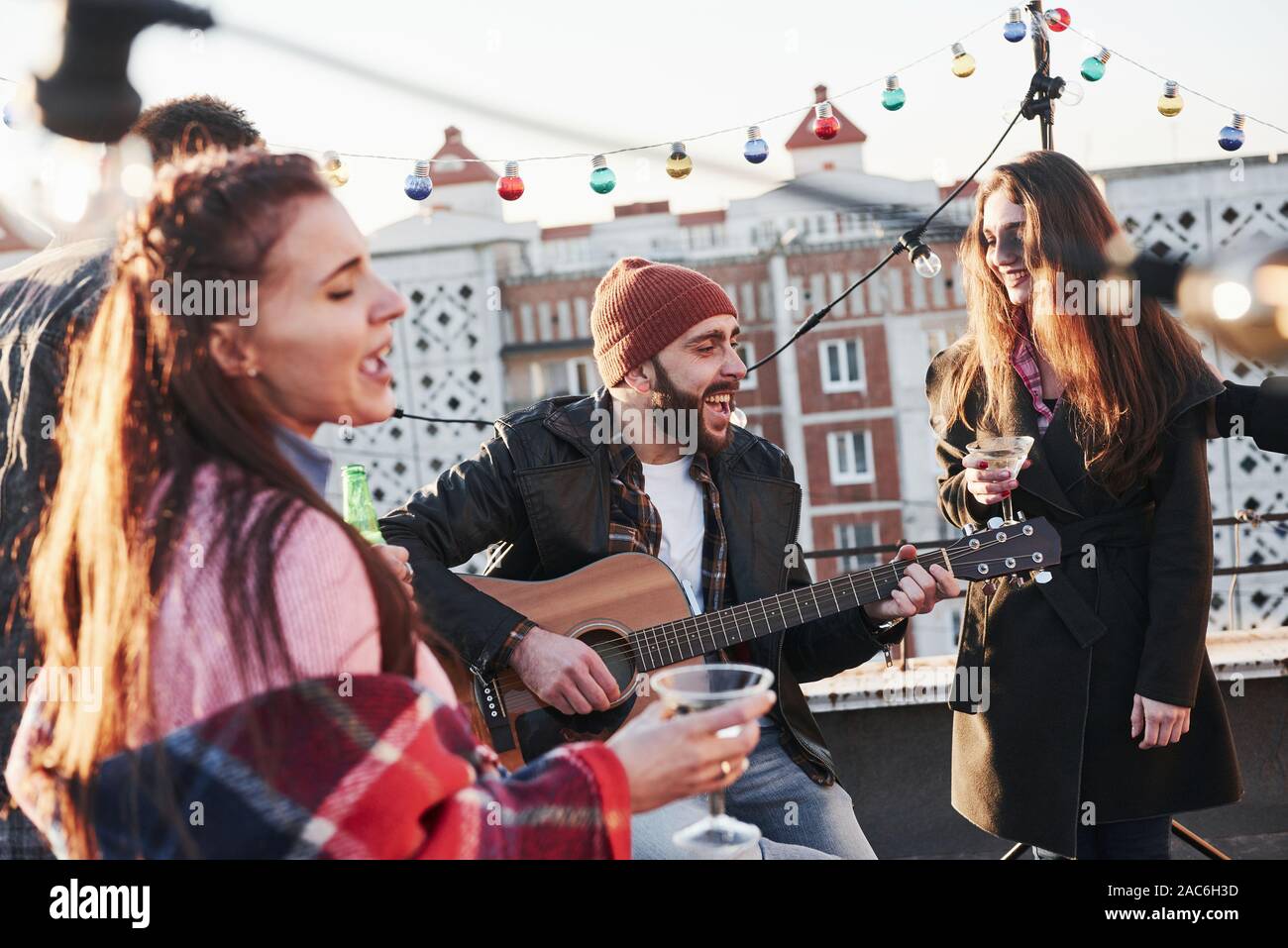Music is unites people. Young friends have party with alcohol and ...