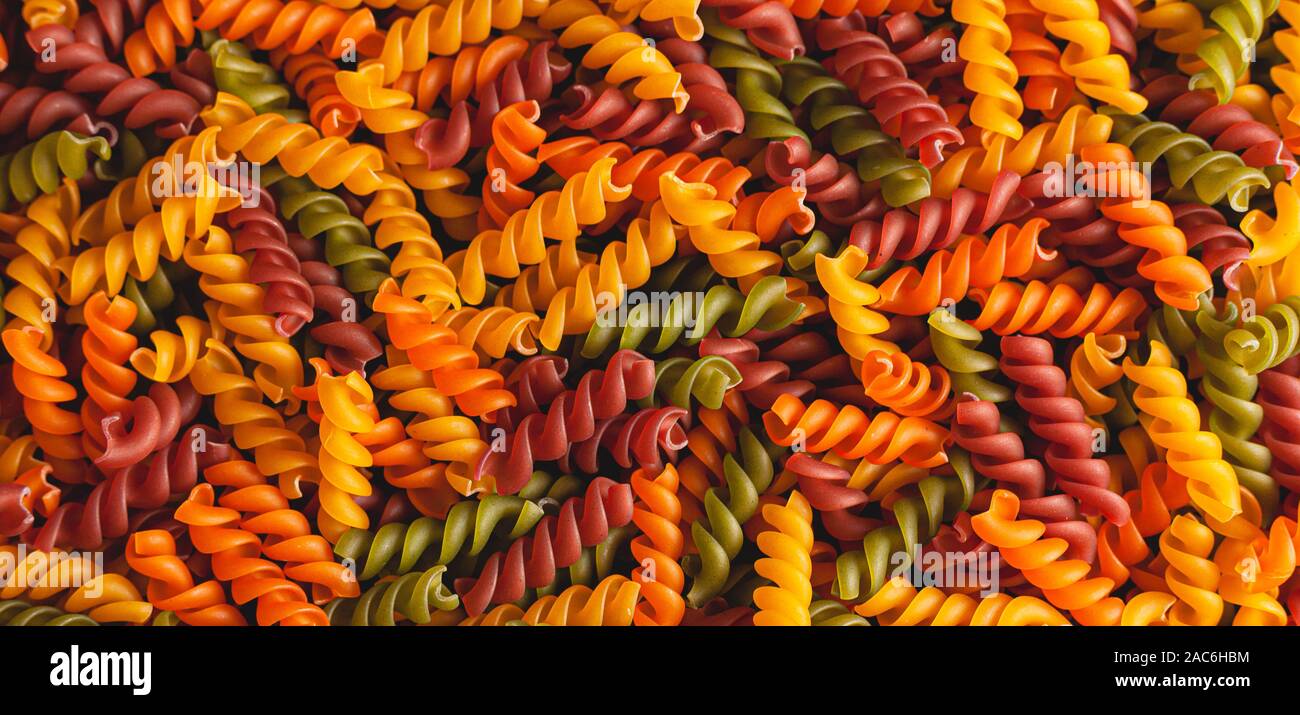 Uncooked tricolore fusilli pasta twist shapes background. Stock photo ...