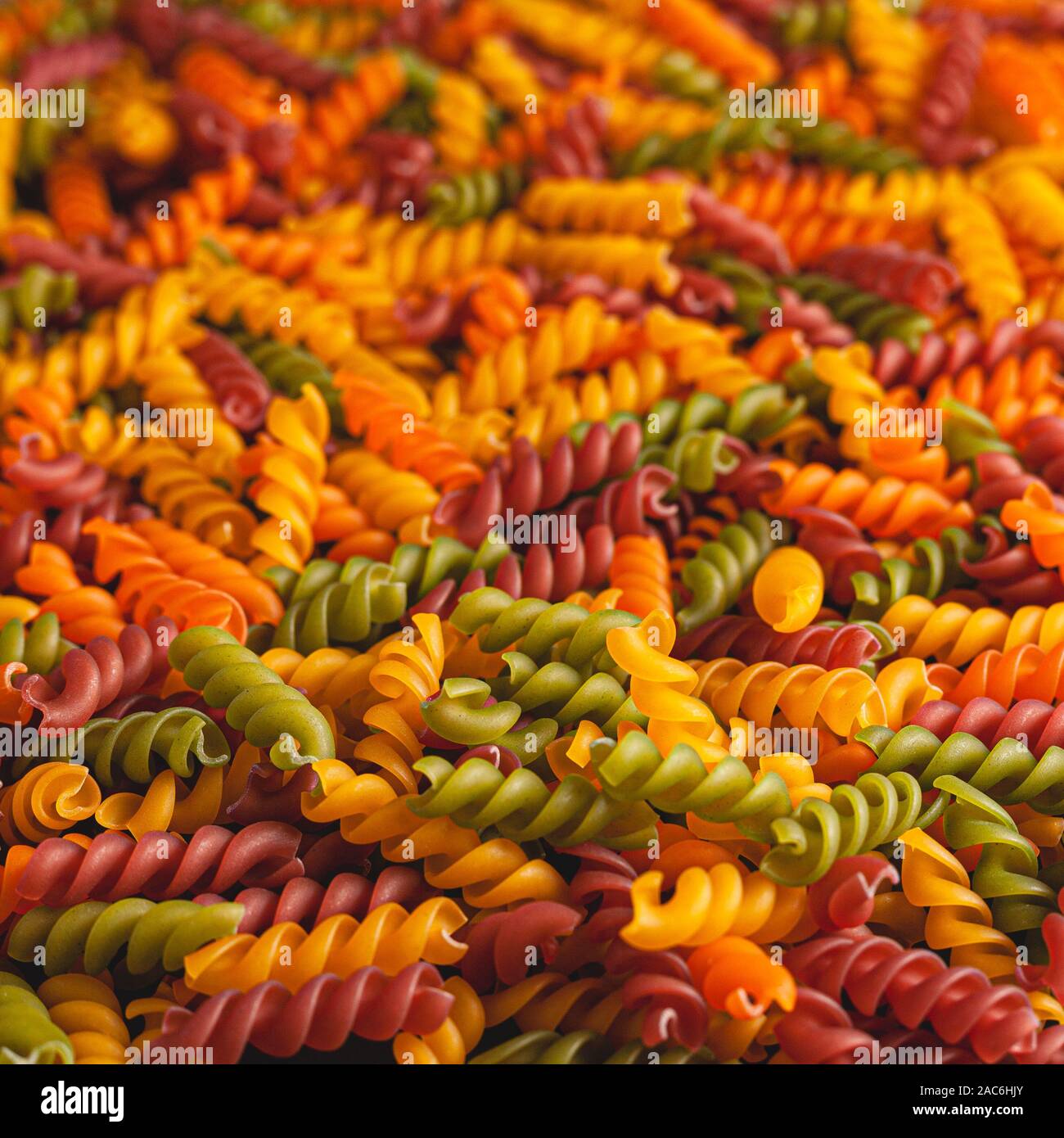 Uncooked tricolore fusilli pasta twist shapes background. Stock photo ...