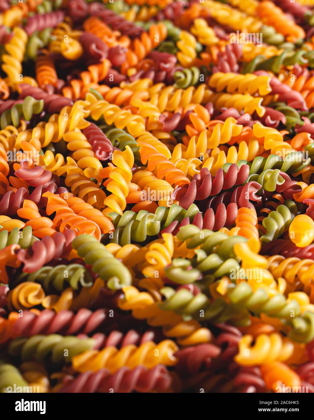 Uncooked tricolore fusilli pasta twist shapes background. Stock photo ...