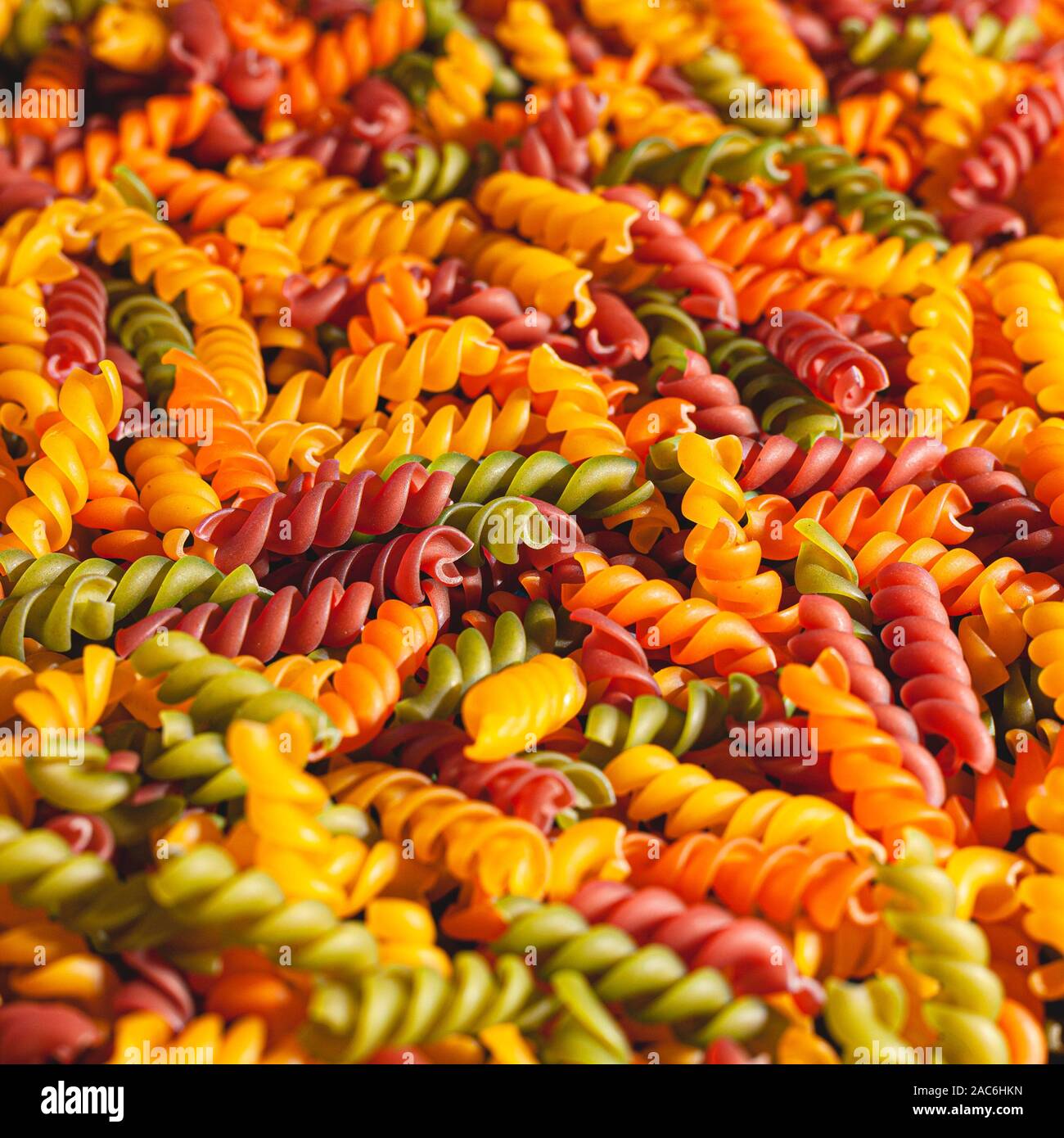 Uncooked tricolore fusilli pasta twist shapes background. Stock photo ...