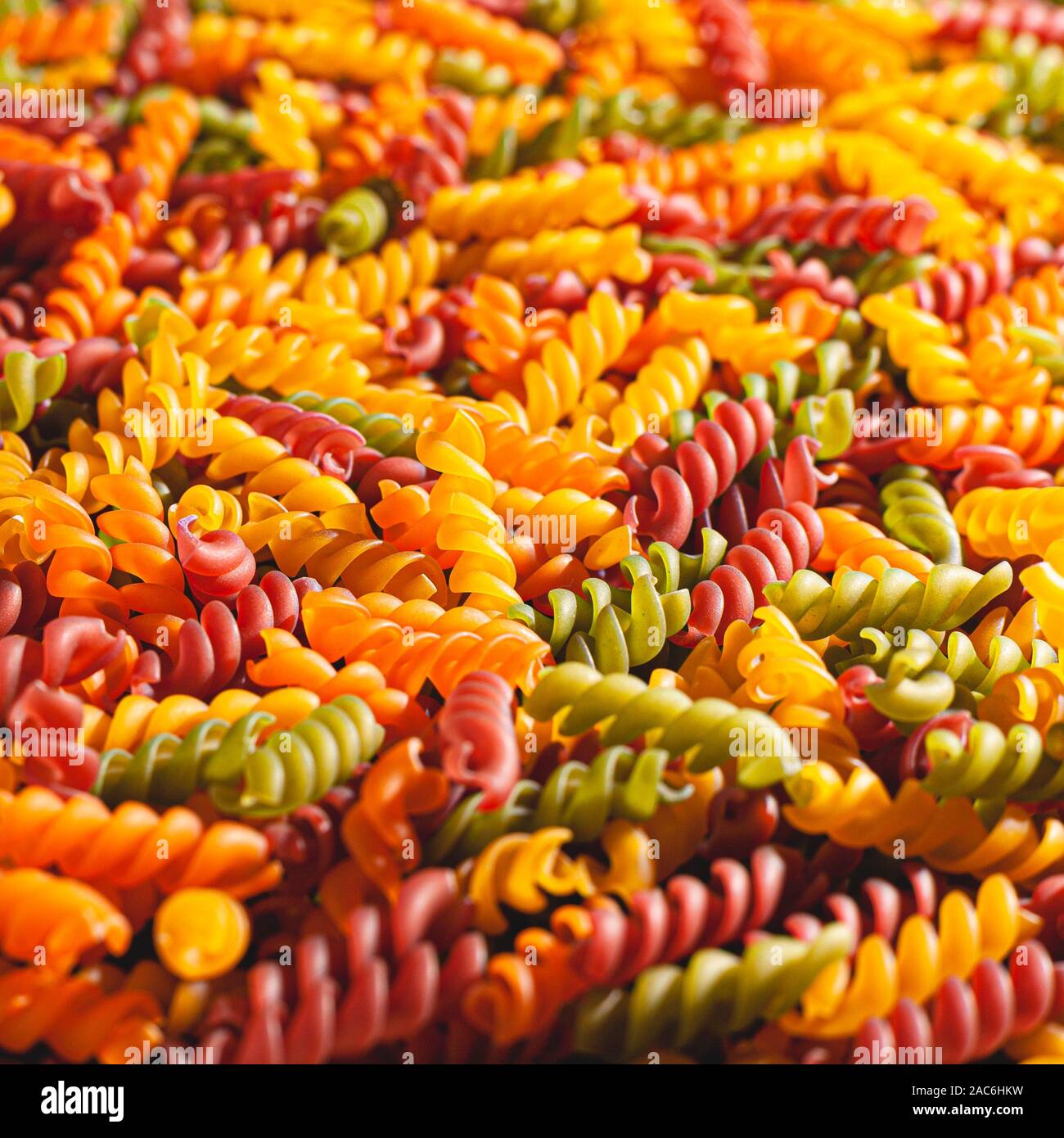 Uncooked tricolore fusilli pasta twist shapes background. Stock photo ...