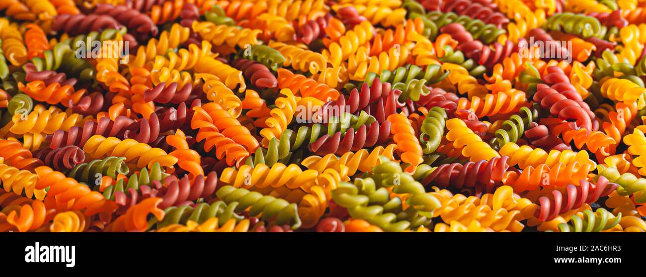 Uncooked tricolore fusilli pasta twist shapes background. Stock photo ...