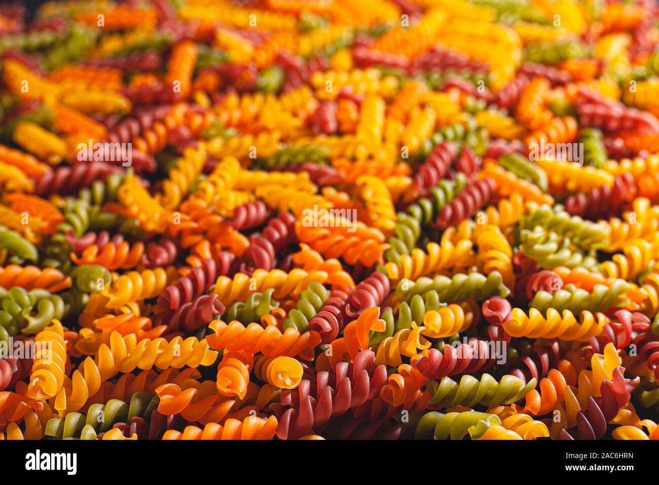 Uncooked tricolore fusilli pasta twist shapes background. Stock photo ...