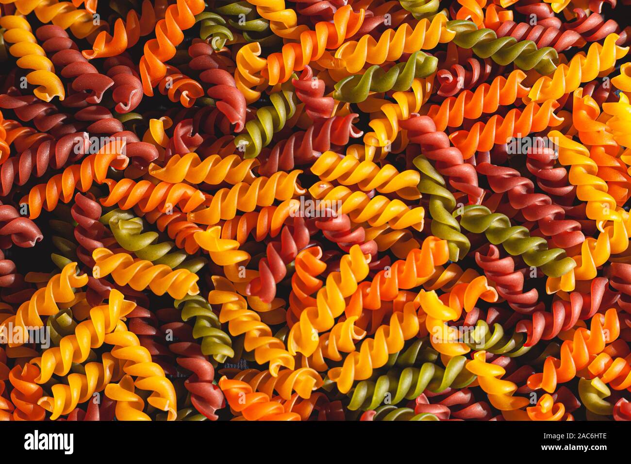 Uncooked tricolore fusilli pasta twist shapes background. Stock photo ...