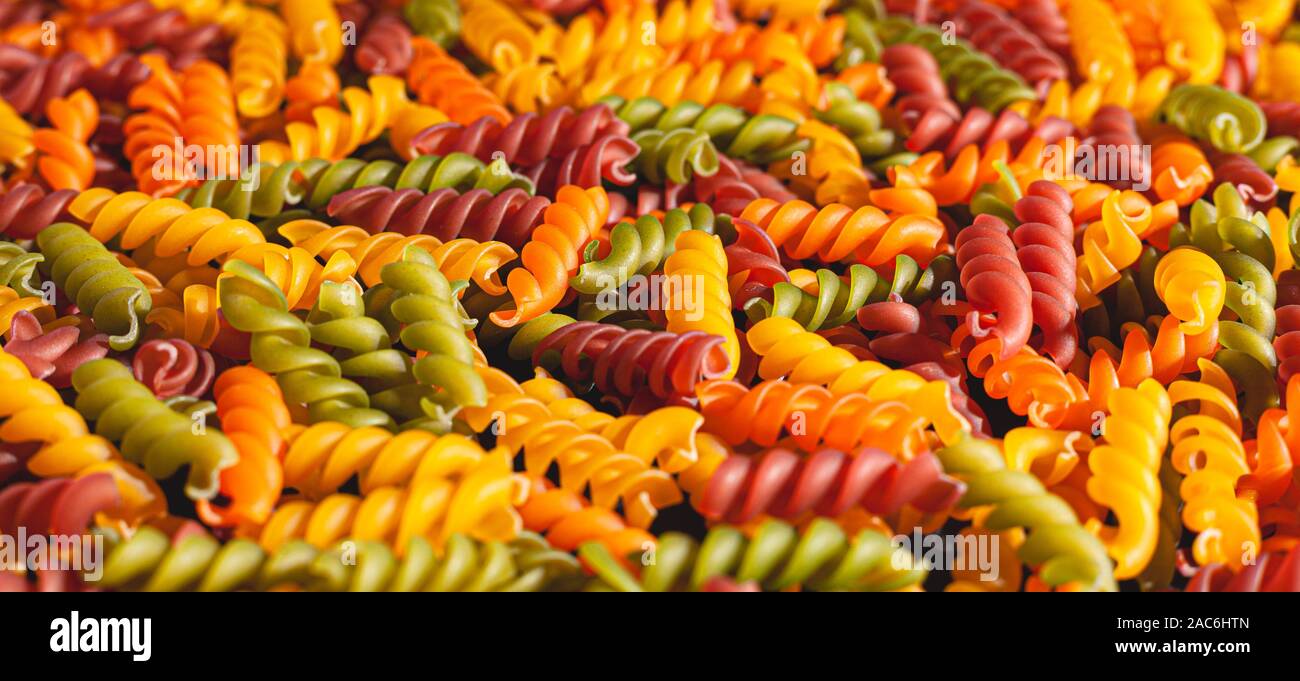 Uncooked tricolore fusilli pasta twist shapes background. Stock photo ...