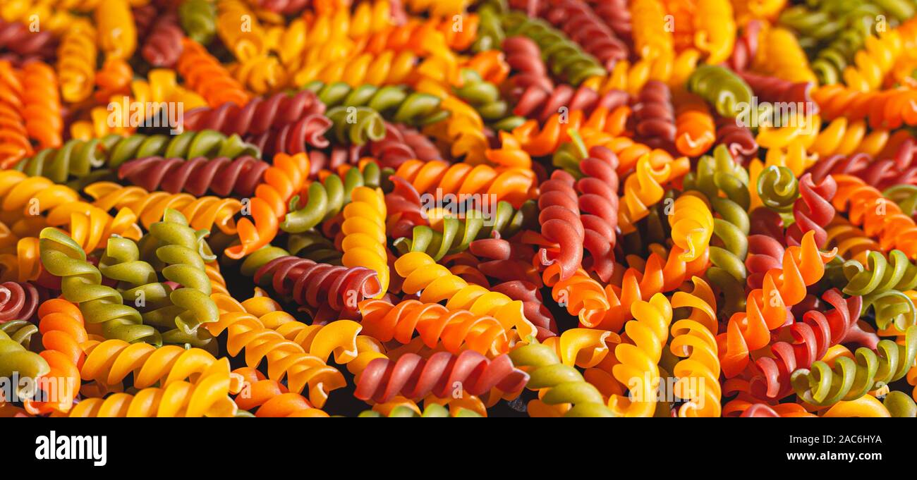Uncooked tricolore fusilli pasta twist shapes background. Stock photo ...
