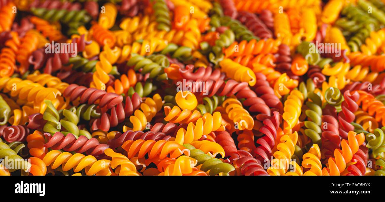 Uncooked tricolore fusilli pasta twist shapes background. Stock photo ...