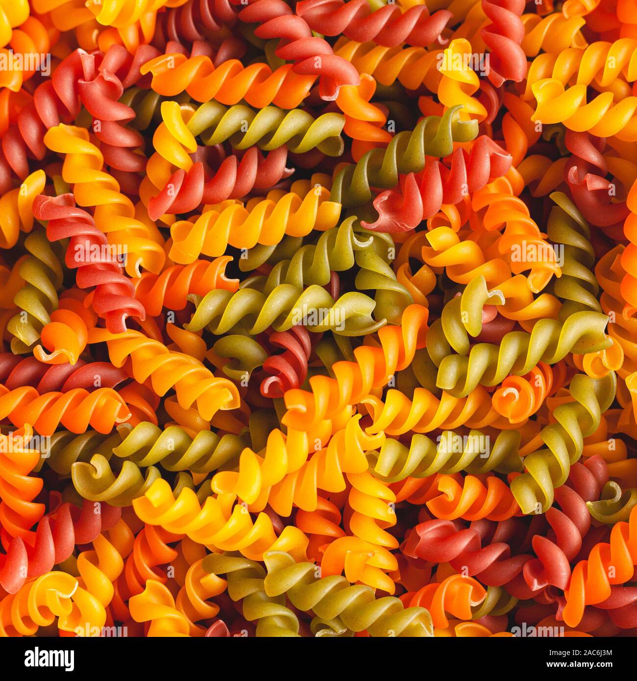 Uncooked tricolore fusilli pasta twist shapes background. Stock photo ...