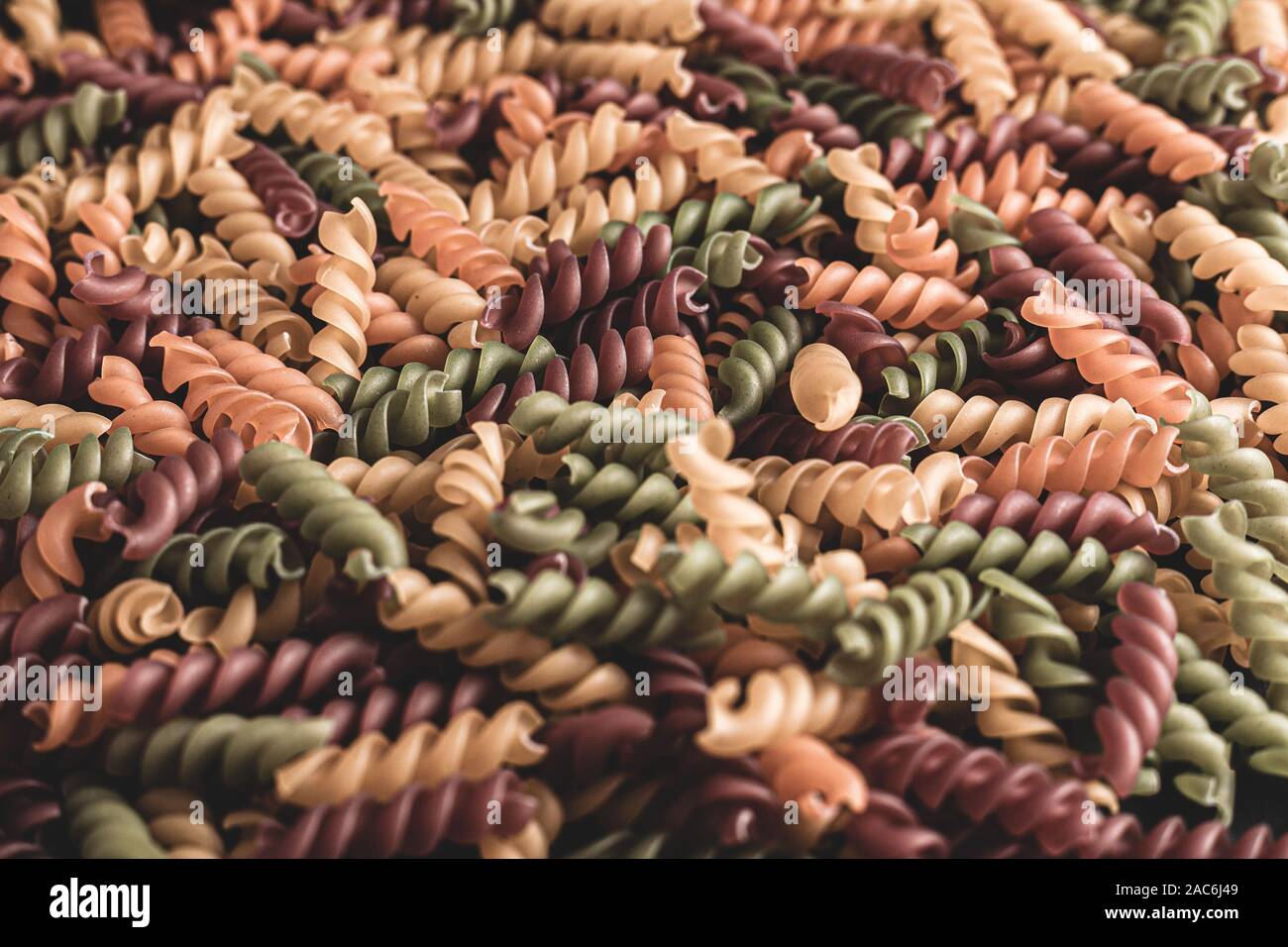 Uncooked tricolore fusilli pasta twist shapes background. Stock photo ...