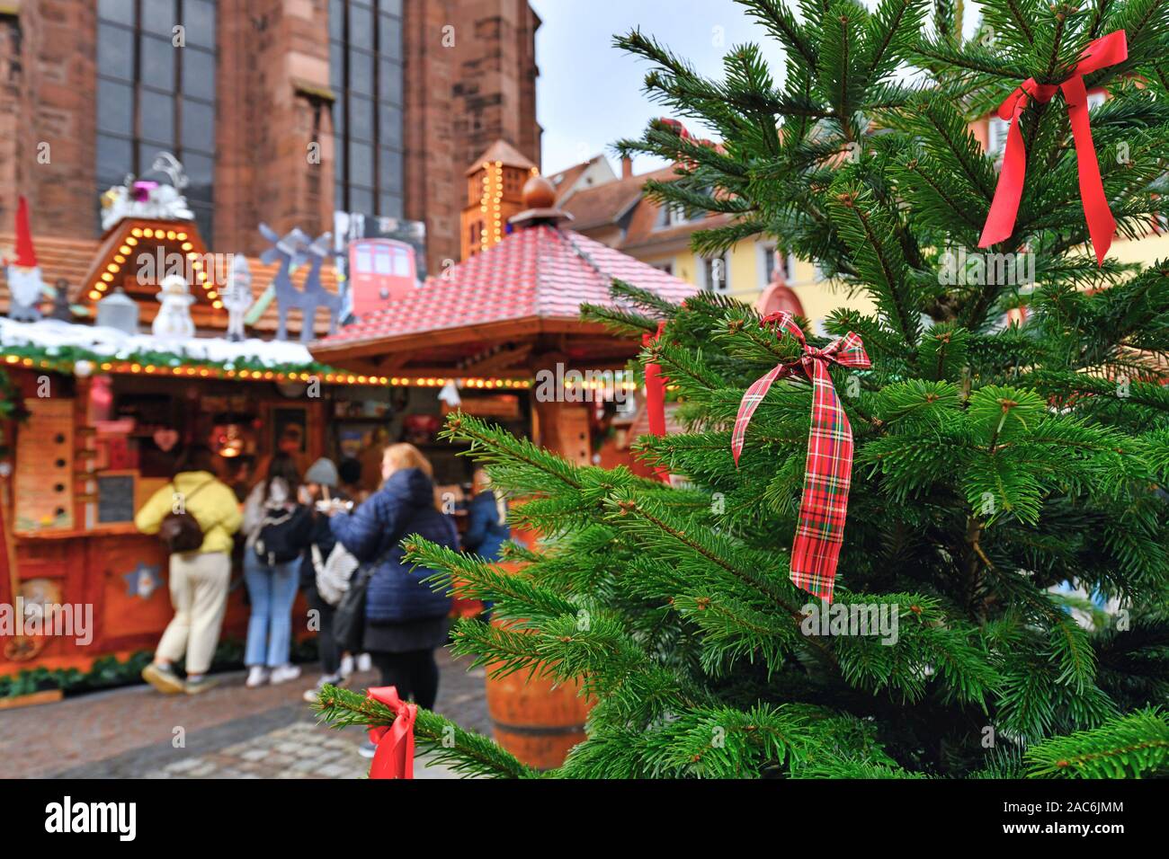 Close up of red ribbon tied to Christmas tree with sales booth and ...